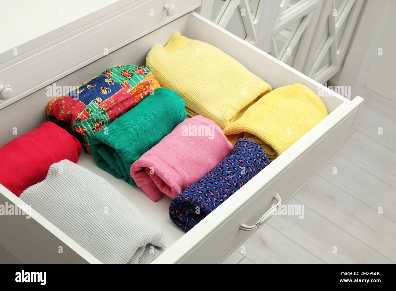 Folded clothes in open drawer. Apparel storage Stock Photo - Alamy