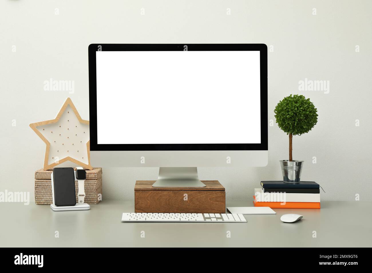 Modern workplace with computer, charging devices and decor elements ...