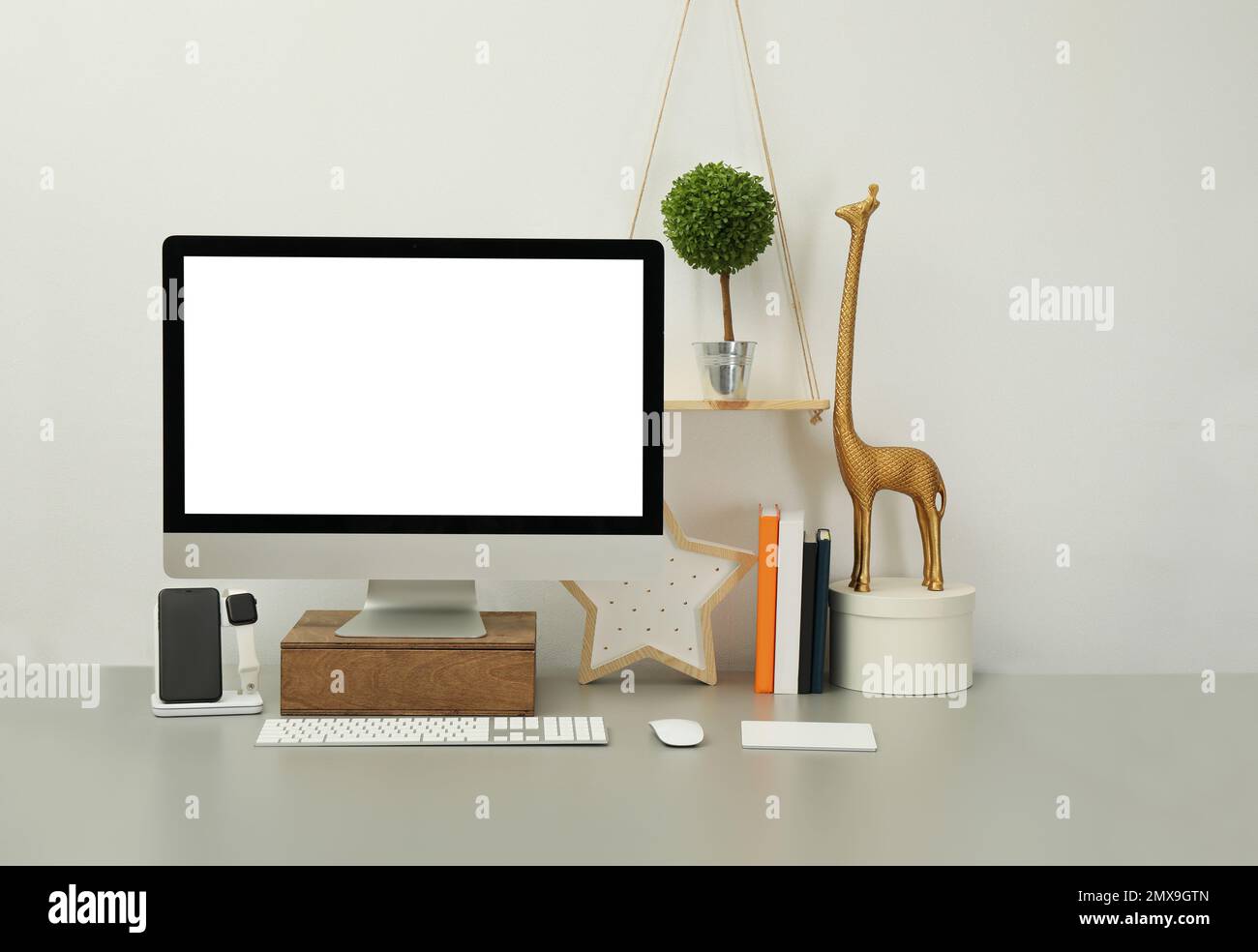 Modern workplace with computer, charging devices and decor elements ...