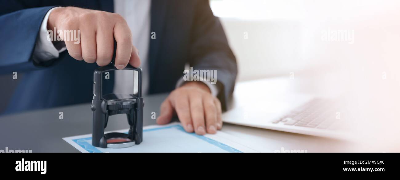 Male lawyer stamping document at desk in office, closeup. Banner design ...