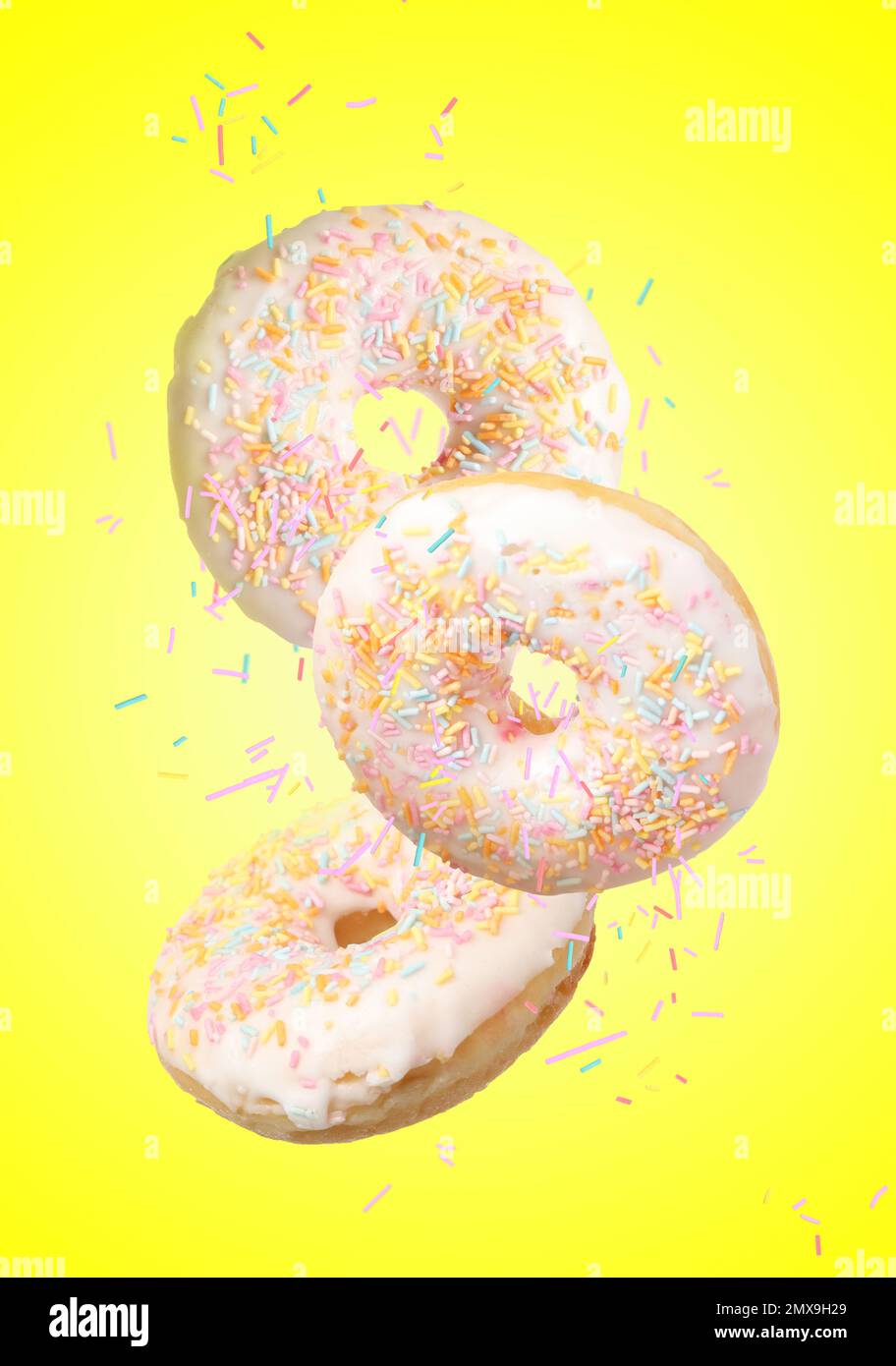Set of falling delicious donuts on yellow background Stock Photo - Alamy
