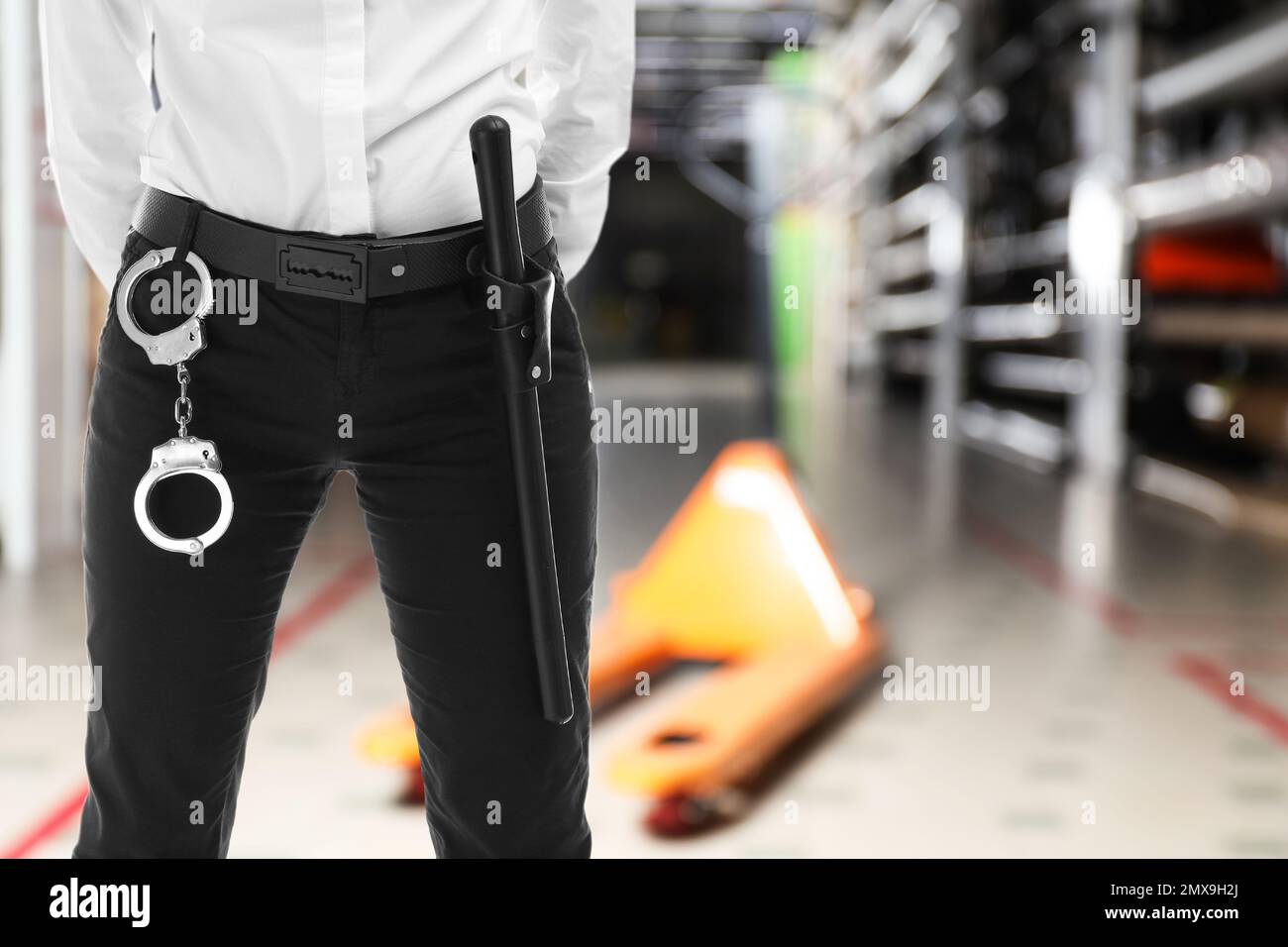 Security guard with handcuffs in wholesale warehouse, closeup. Space ...