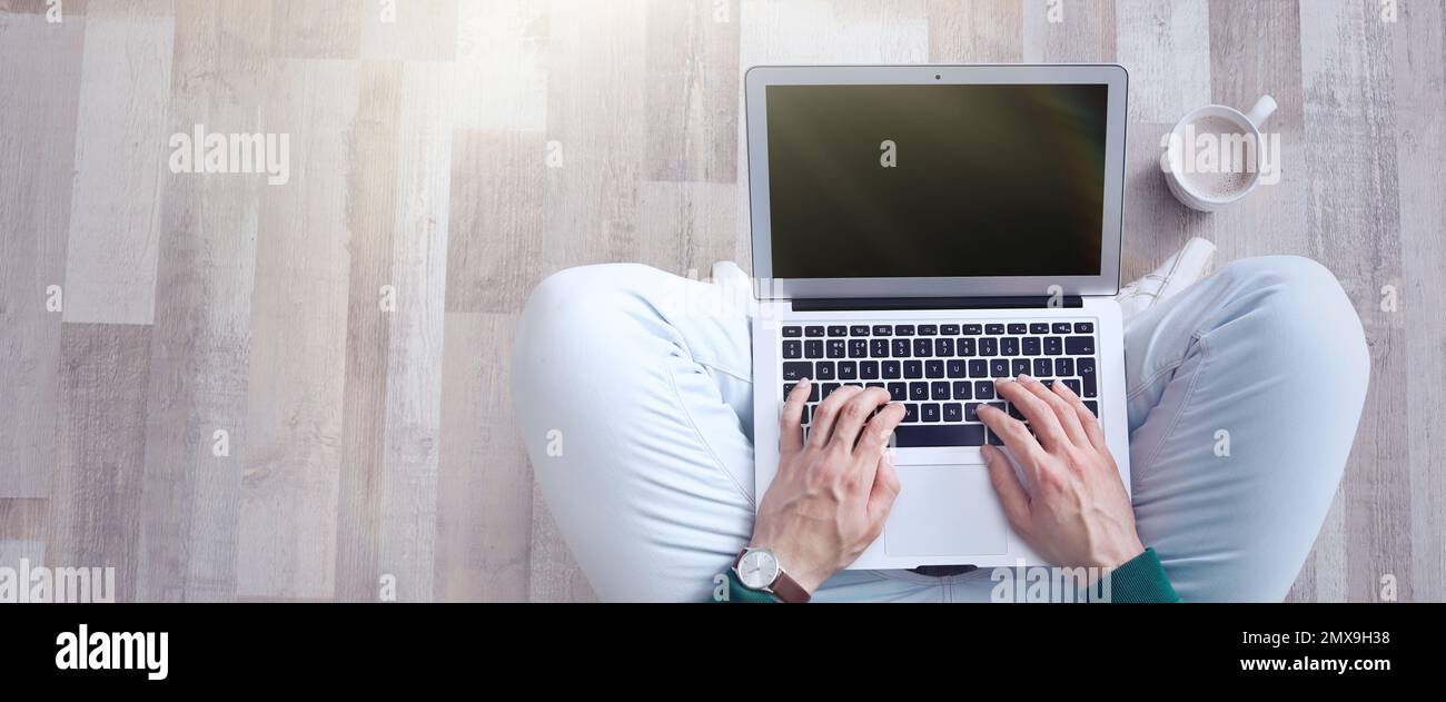 Young man working on computer indoors, top view with space for text ...