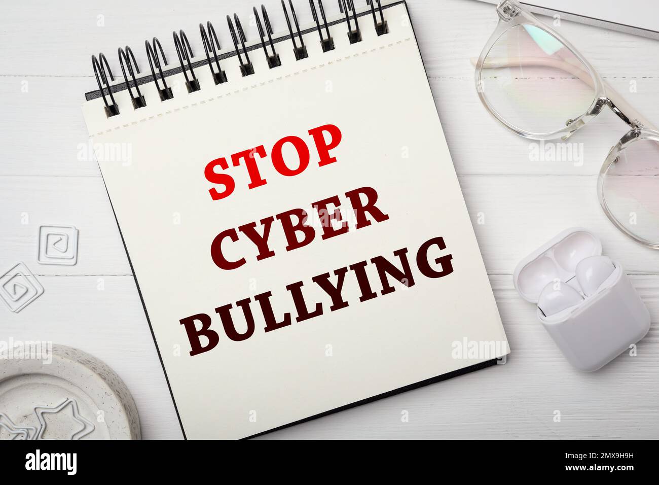 Notebook with phrase STOP CYBER BULLYING, eyeglasses and earphones on ...