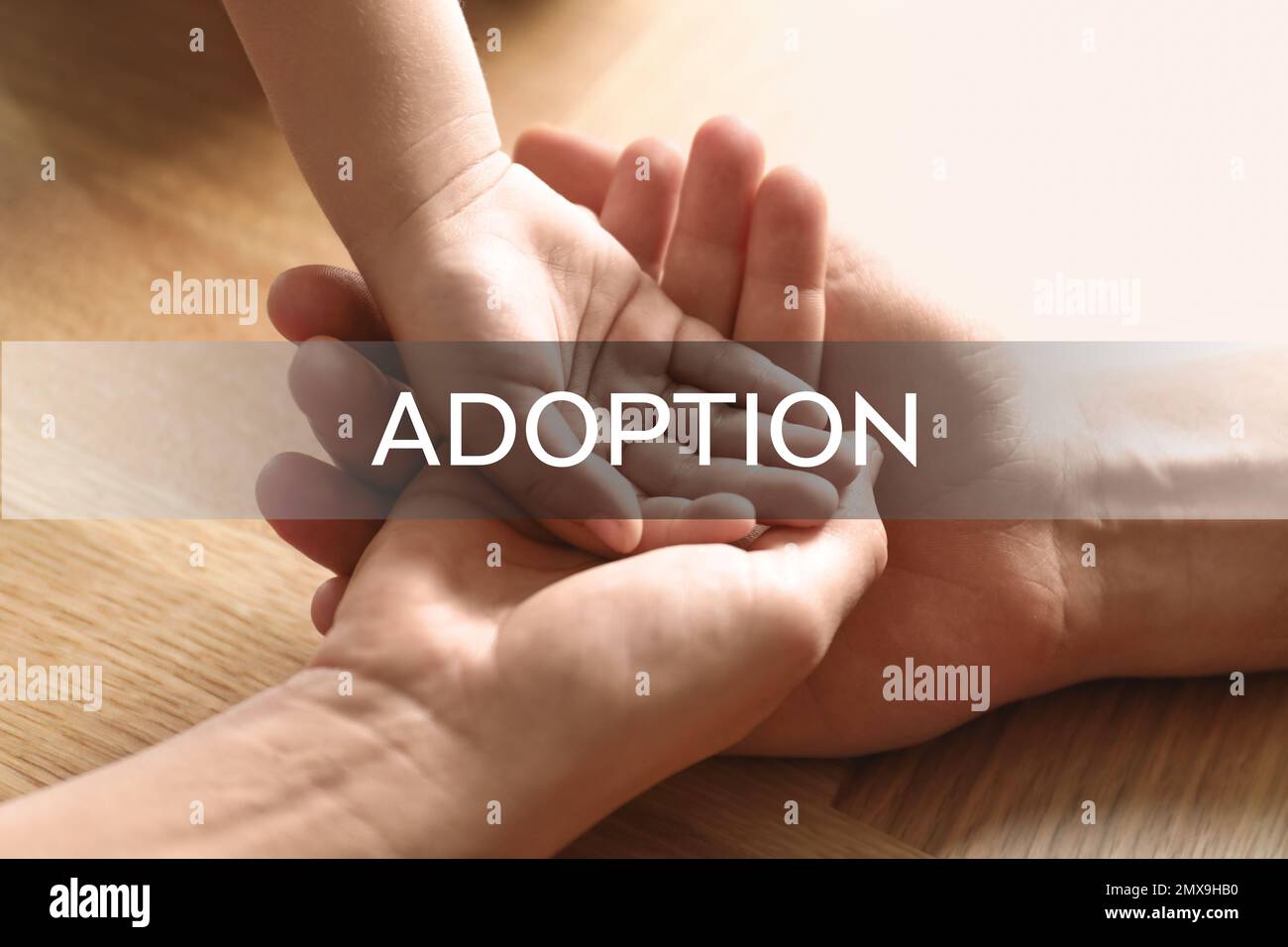 Happy family holding hands on wooden background, closeup. Child ...