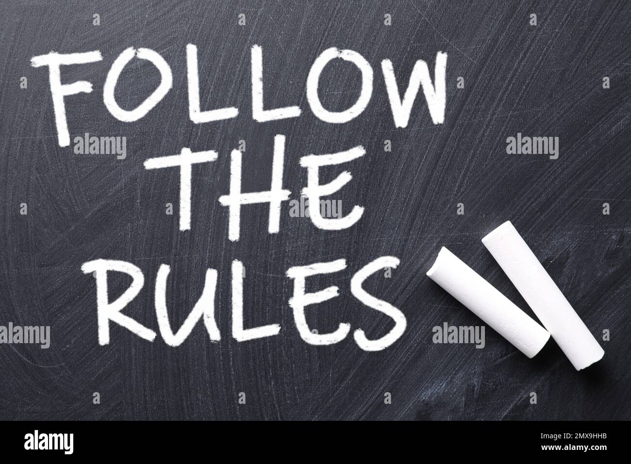 Chalk and text FOLLOW THE RULES on blackboard Stock Photo - Alamy