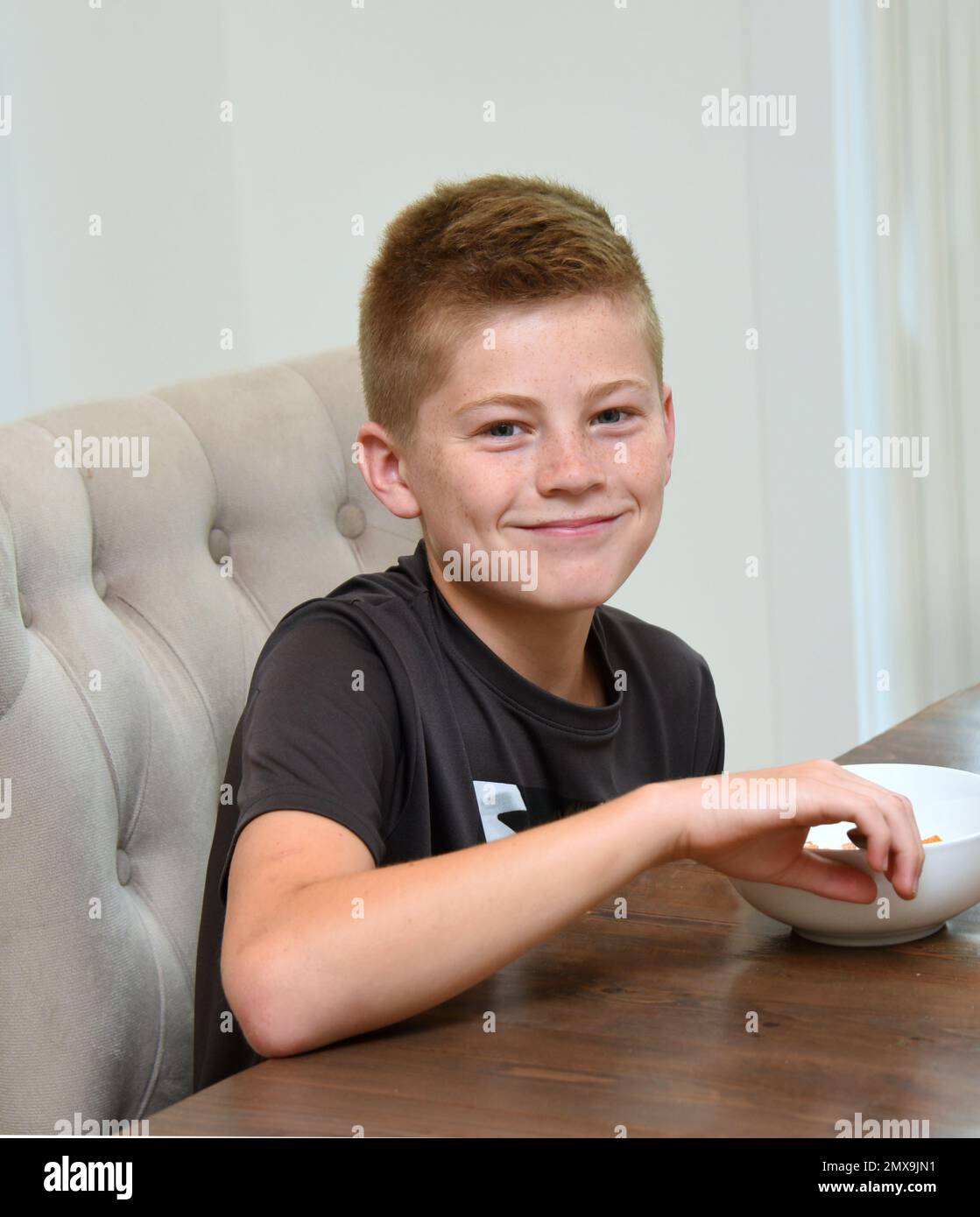 Breakfast gets this young boy going in the morning. He is grinning over ...