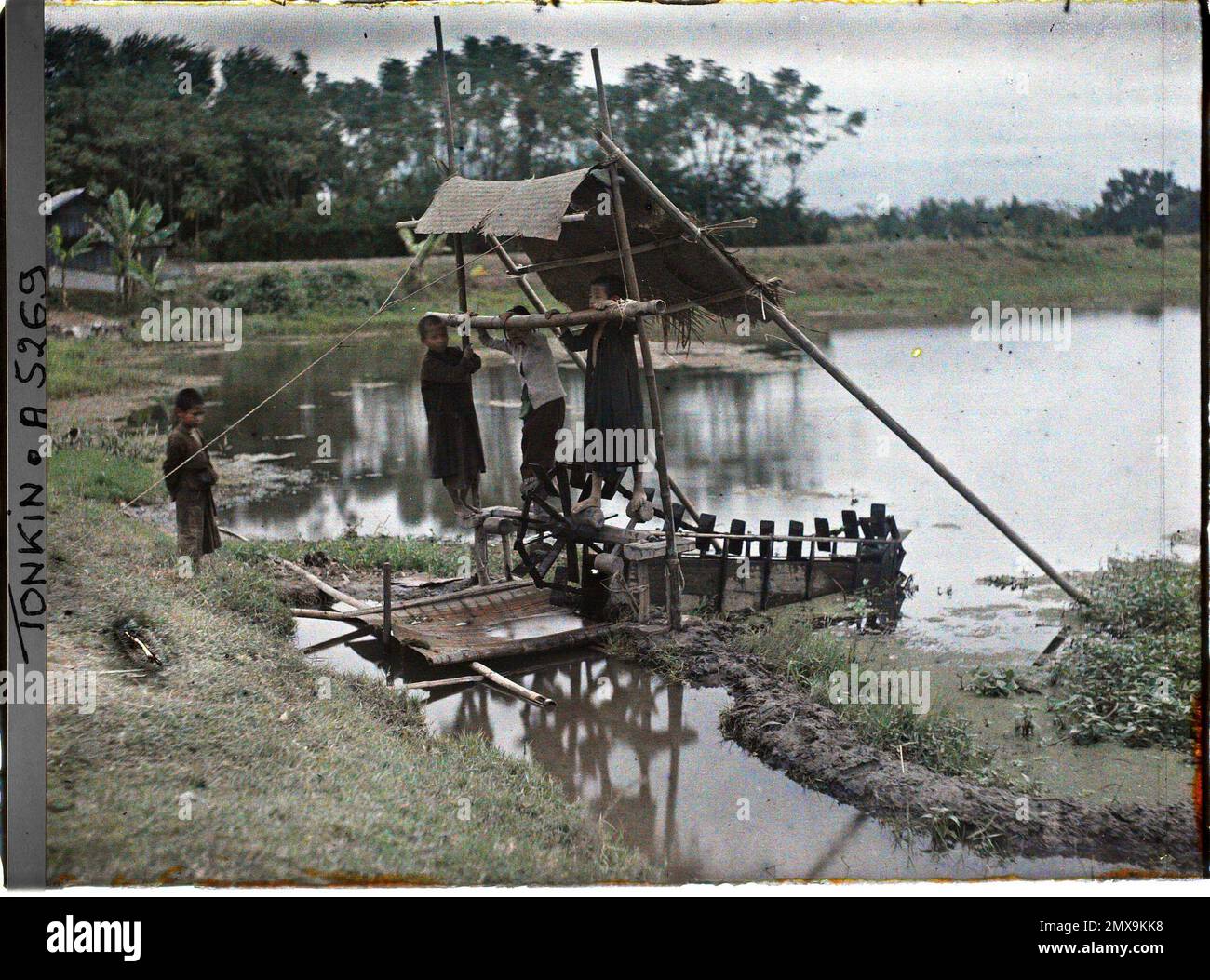 Tonkin, Indochina of children using a machine on foot, a lifting system ...