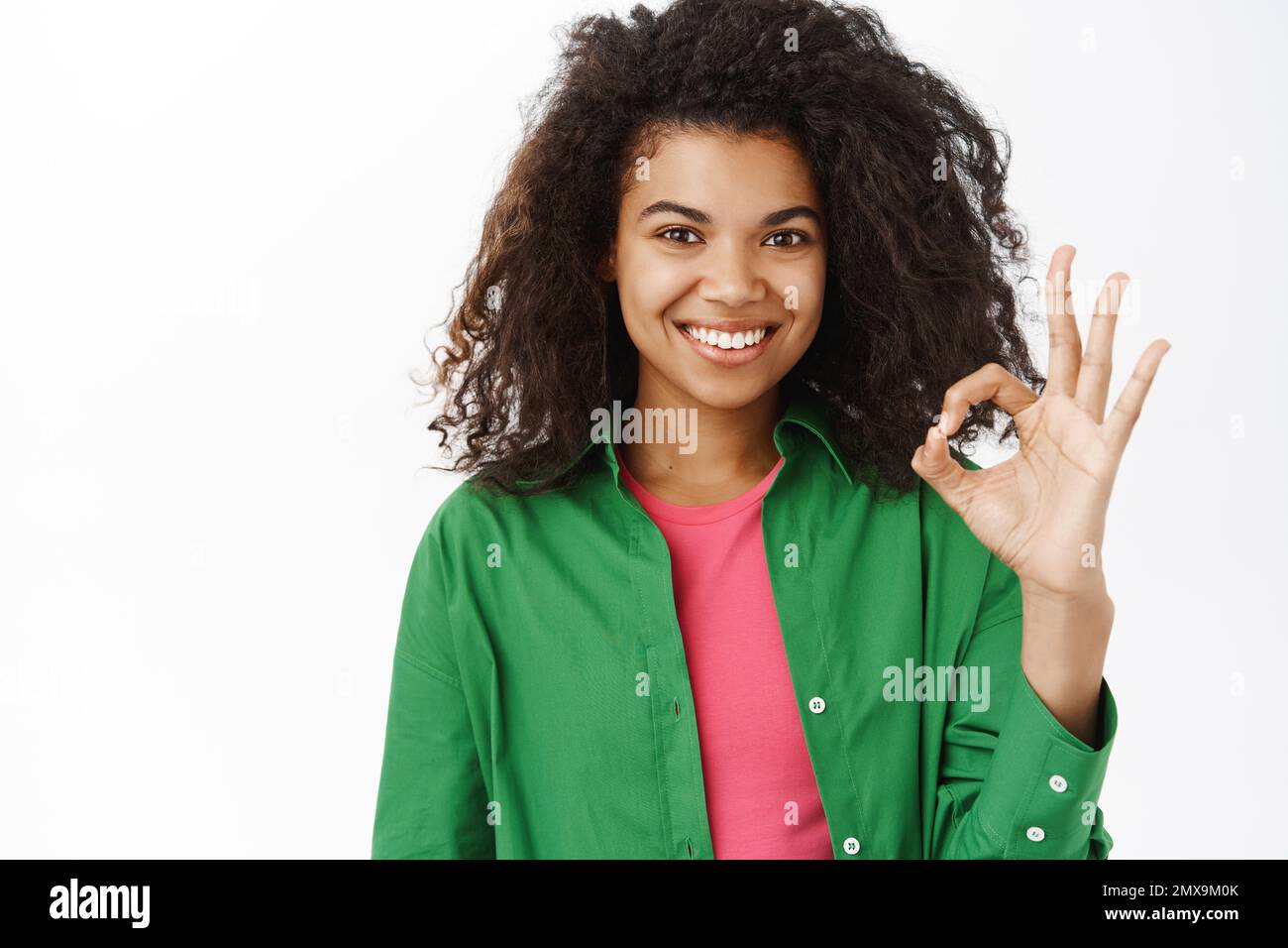 Perfect, no problem. Happy smiling young curly woman, shows zero, okay ...
