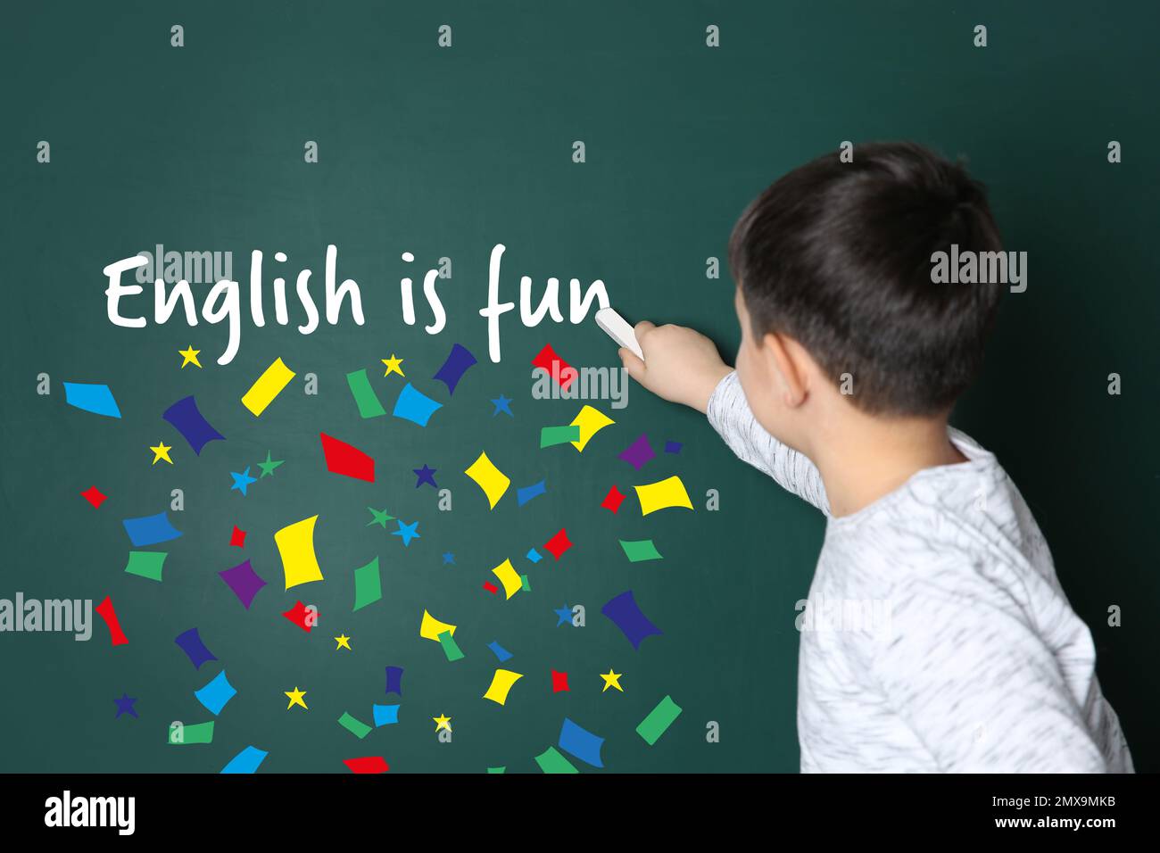 Cute little boy writing ENGLISH IS FUN on chalkboard Stock Photo - Alamy