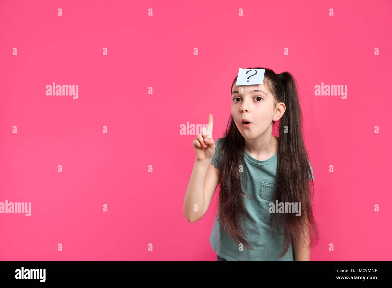 Emotional girl with question mark sticker on forehead against pink ...