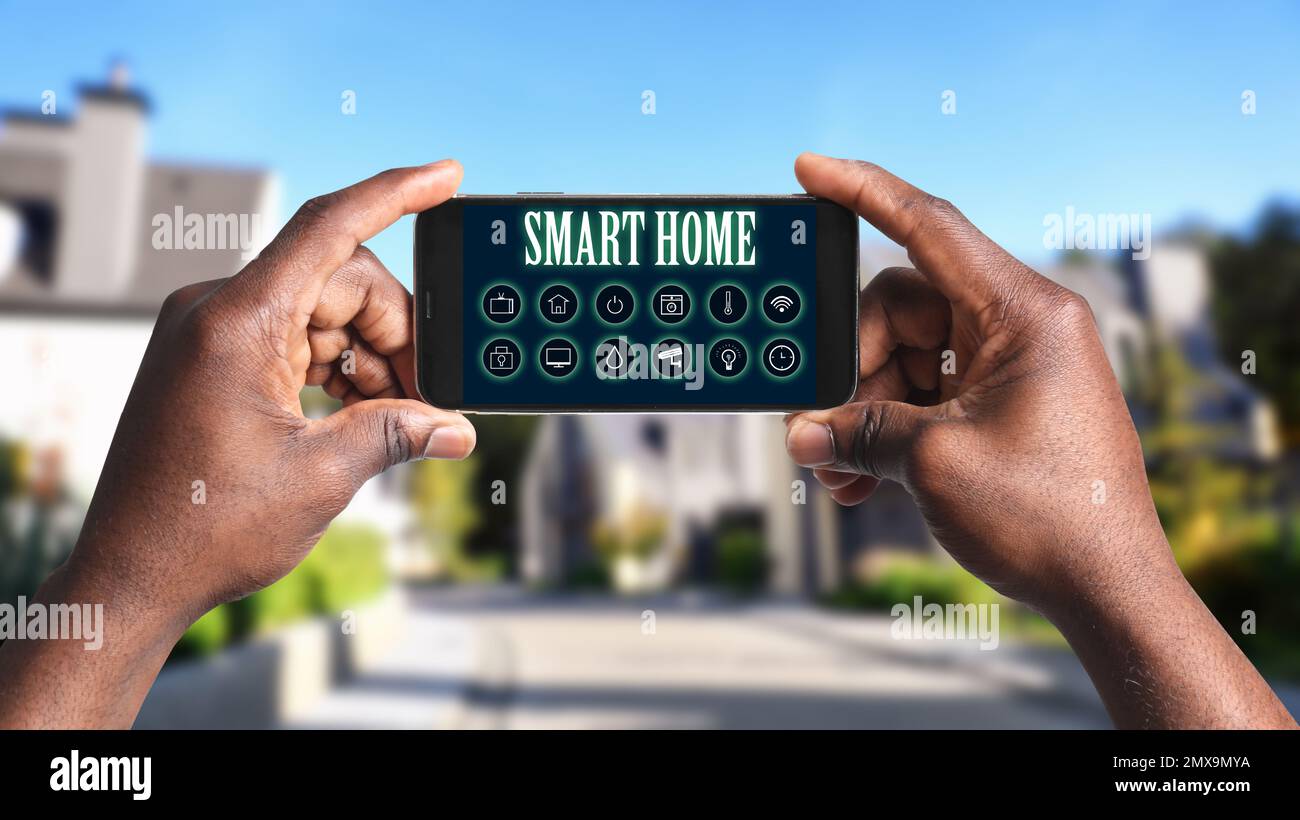 Man using phone application for controlling smart home outdoors ...