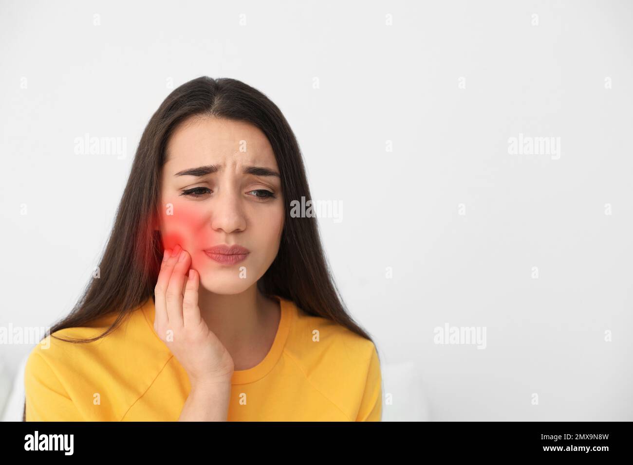Young woman suffering from toothache on white background Stock Photo ...
