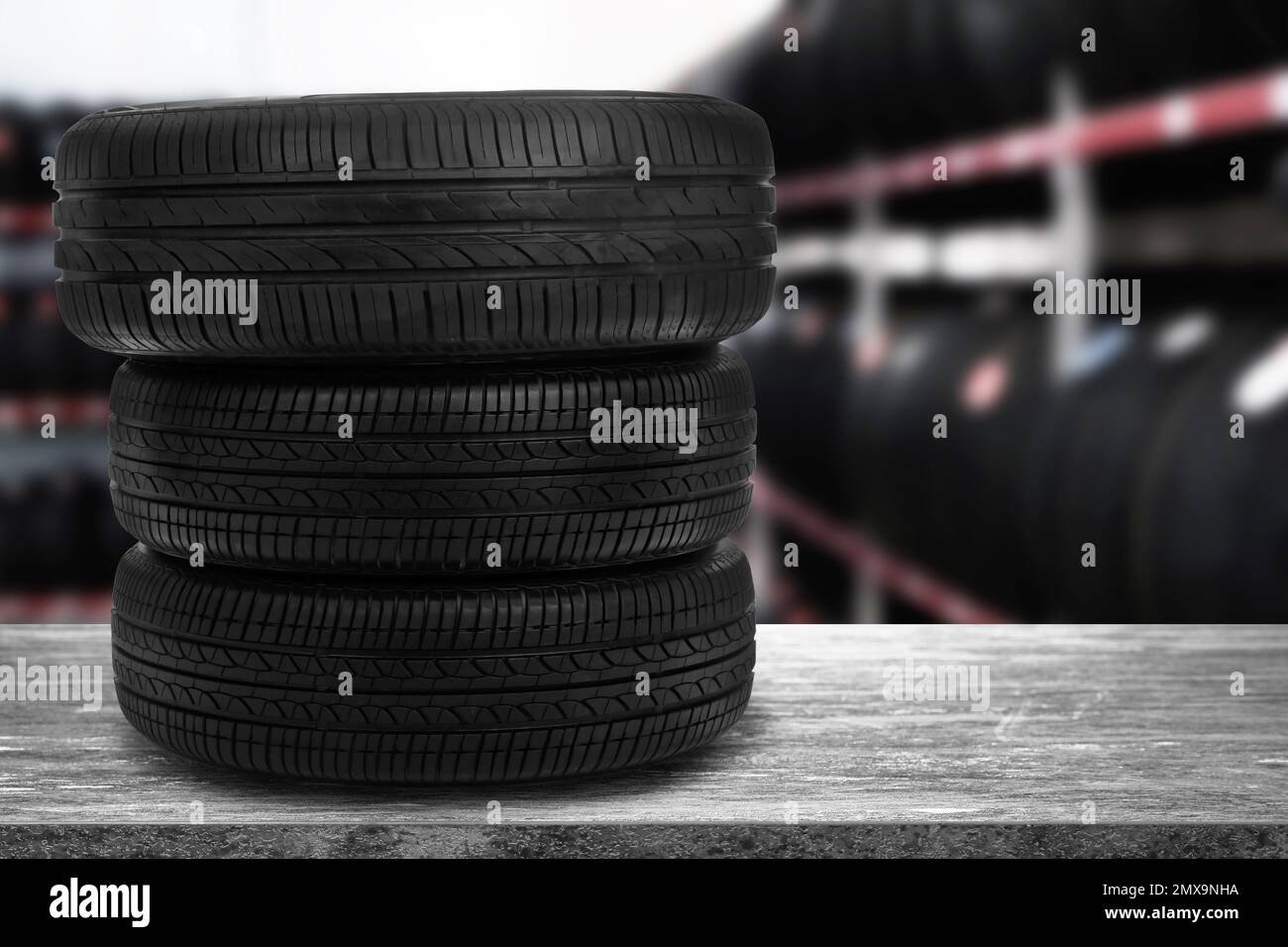 Car tires on grey stone surface in auto store Stock Photo - Alamy