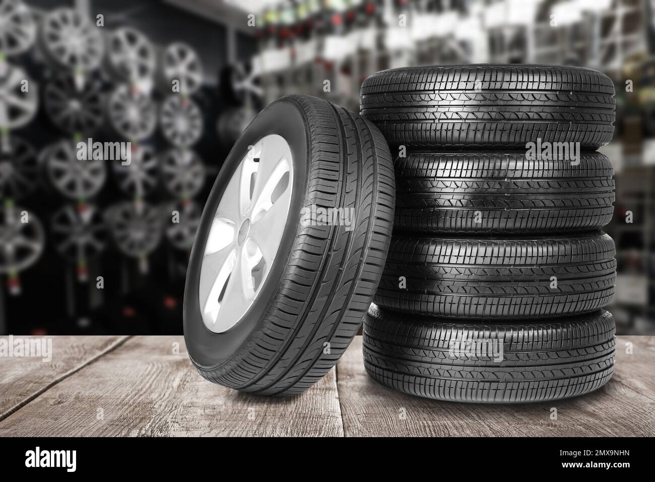 Car tires on grey wooden surface in auto store Stock Photo - Alamy