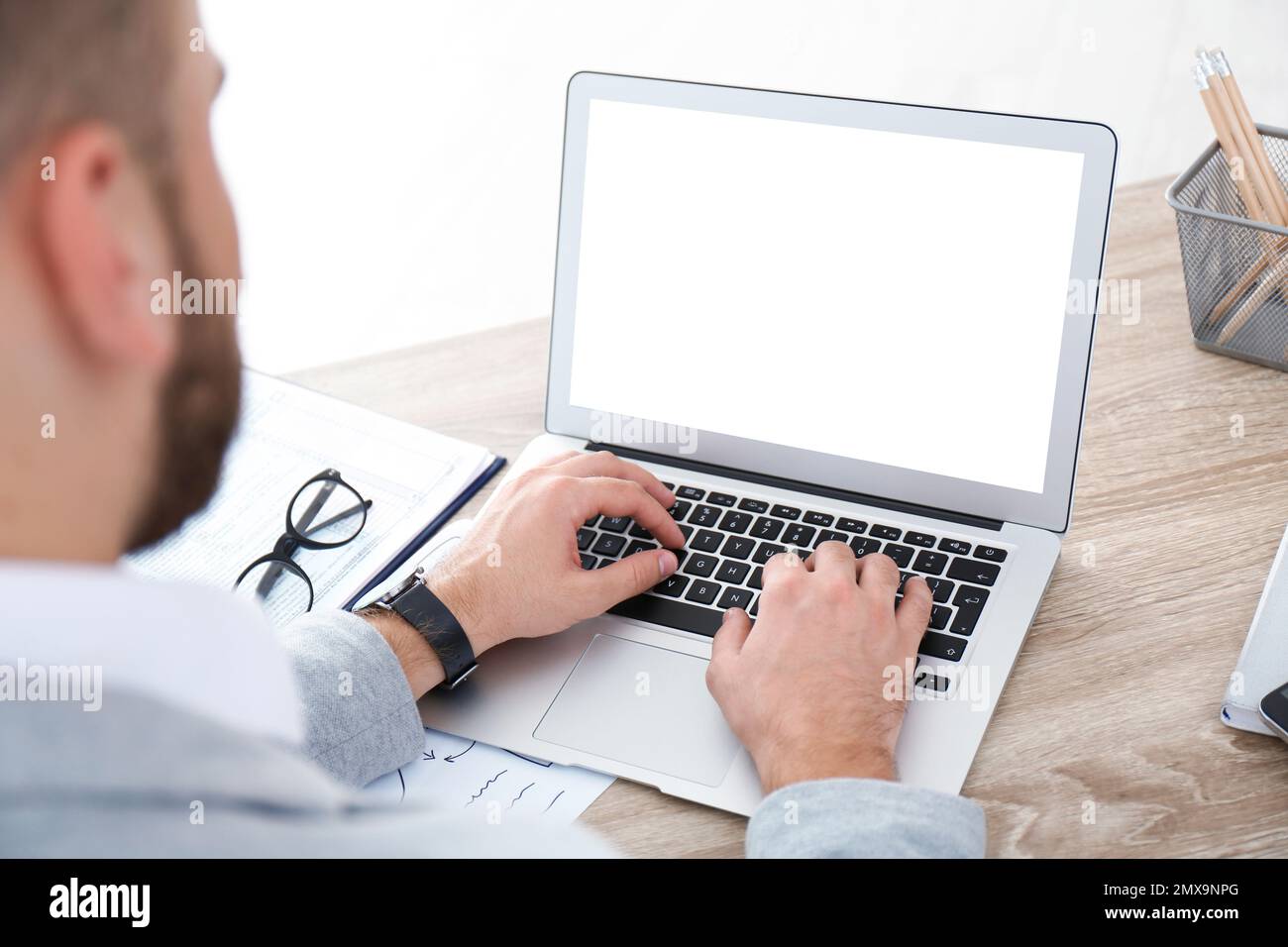 Young man using modern computer at table in office, closeup. Space for ...