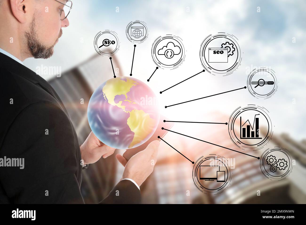 Man demonstrating directions of SEO. World globe with icons of keyword ...