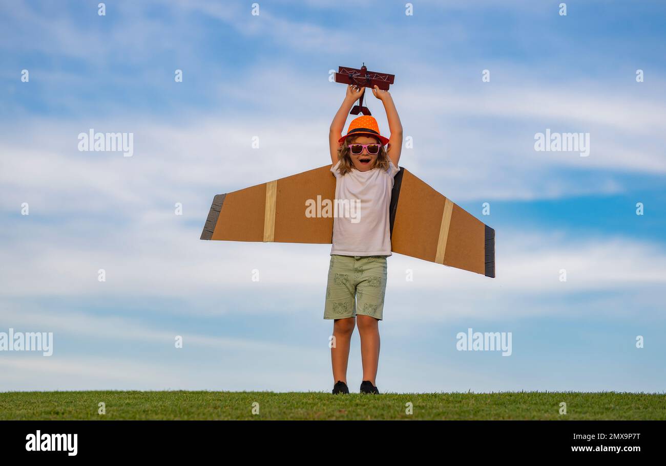 Child playing. Portrait of child with toy paper wings outdoor. Success ...