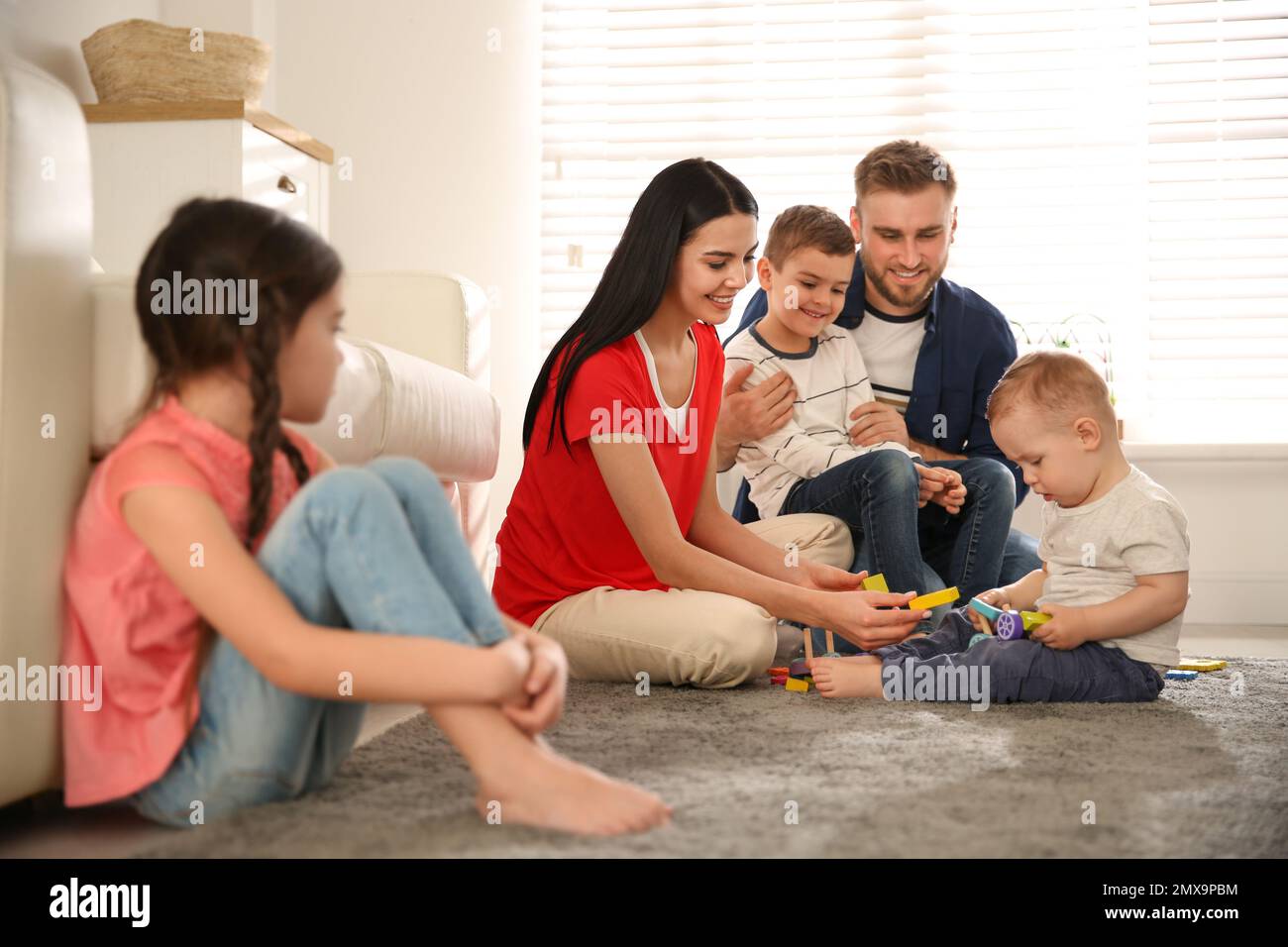 Unhappy little girl feeling jealous while parents spending time with ...