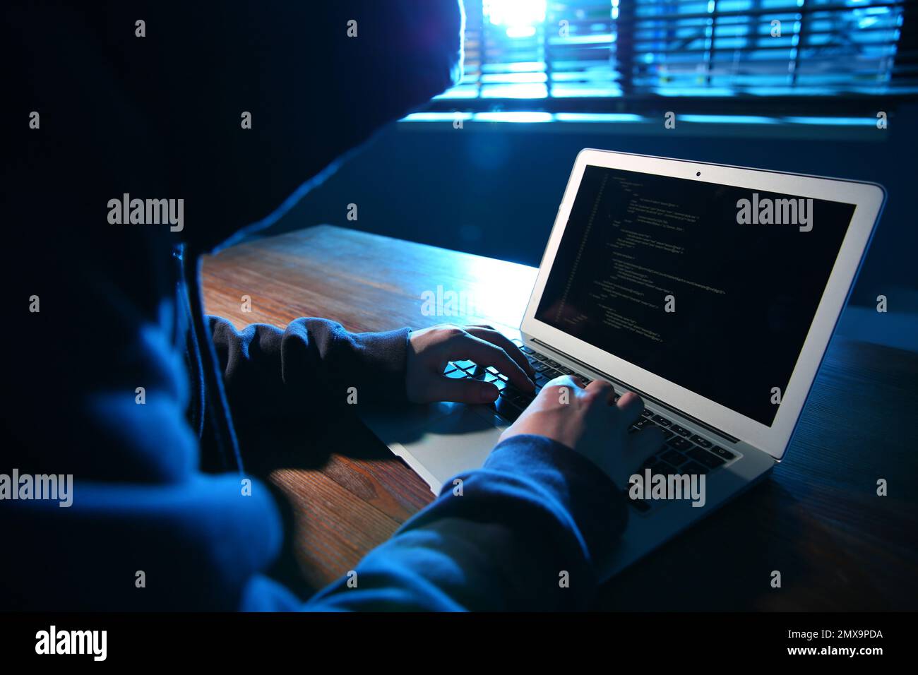 Hacker with laptop in dark room. Cyber crime Stock Photo - Alamy