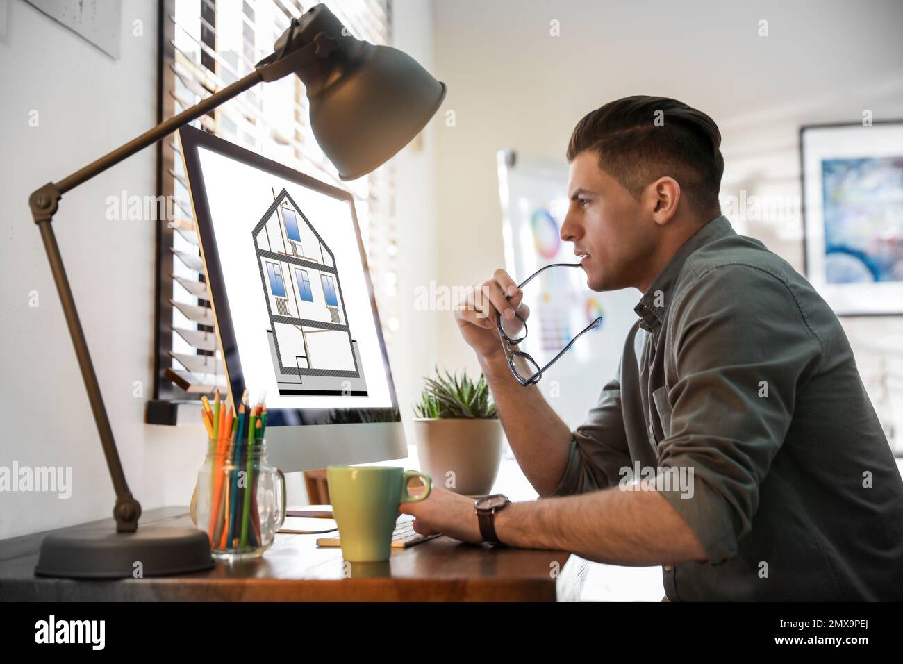Engineer at work. Man projecting house in office Stock Photo - Alamy