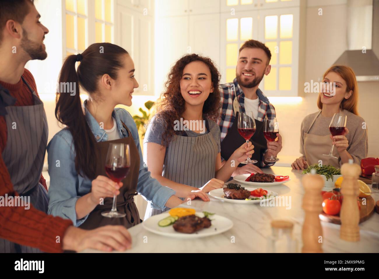 Happy people cooking food together in kitchen Stock Photo - Alamy