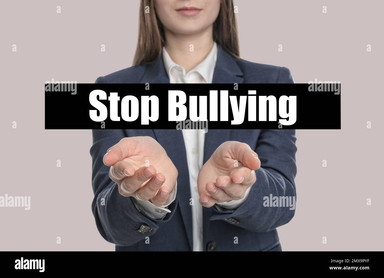 Young woman showing sign STOP BULLYING on light background, closeup ...