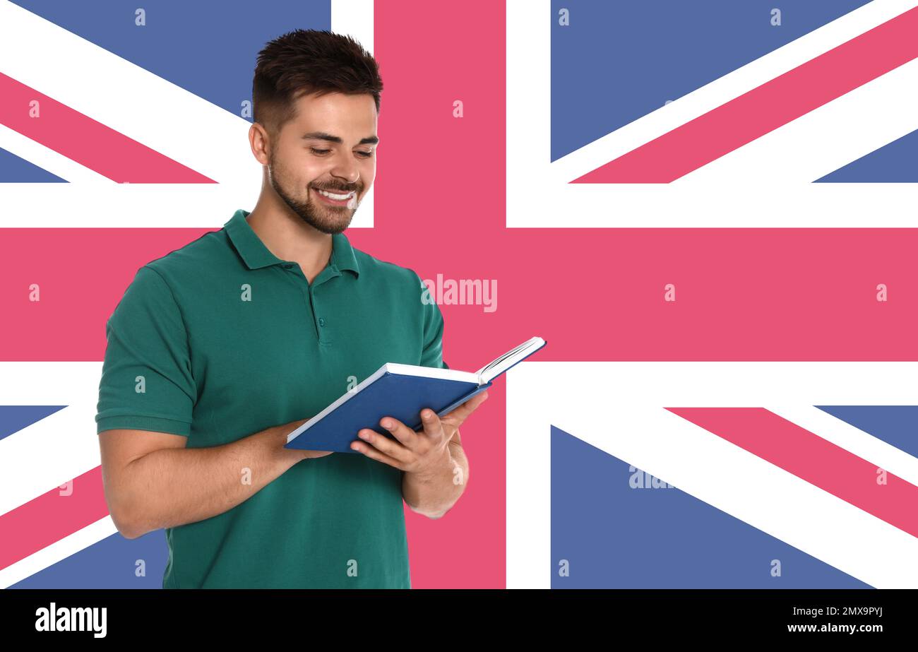 Handsome young man reading book and flag of Great Britain as background ...
