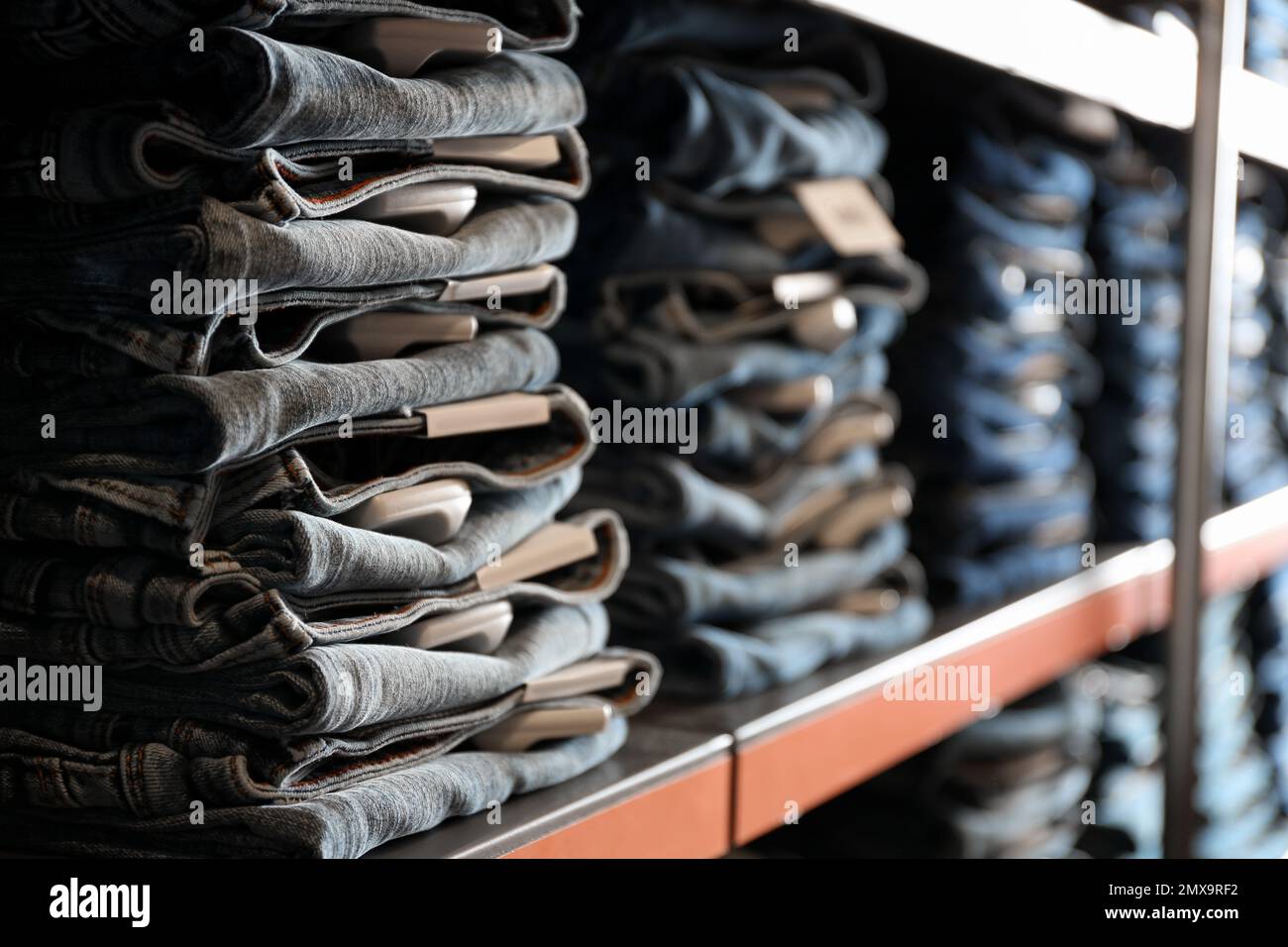 Collection of modern jeans on shelf in shop, closeup Stock Photo - Alamy