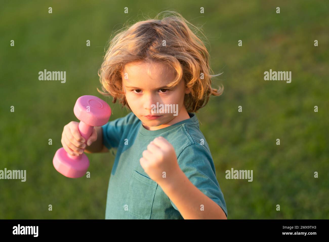 Cute child boy pumping up arm muscles with dumbbell. Fitness kids with dumbbells Stock Photo - Alamy