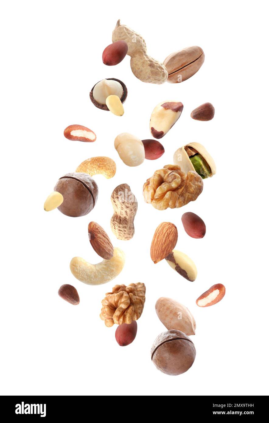 Different nuts falling on white background Stock Photo - Alamy