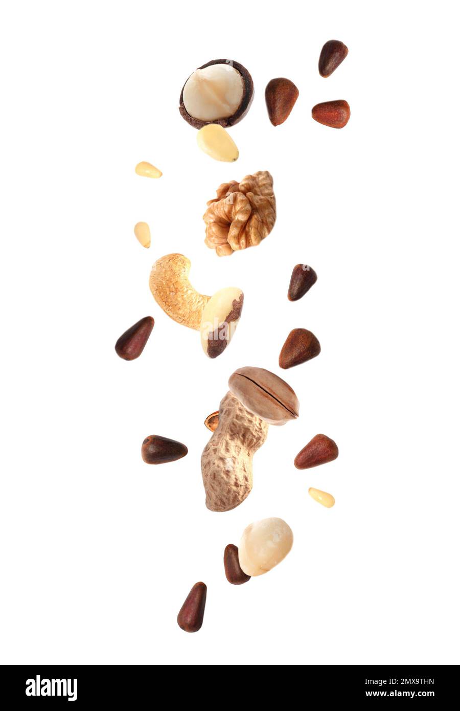 Different nuts falling on white background Stock Photo - Alamy