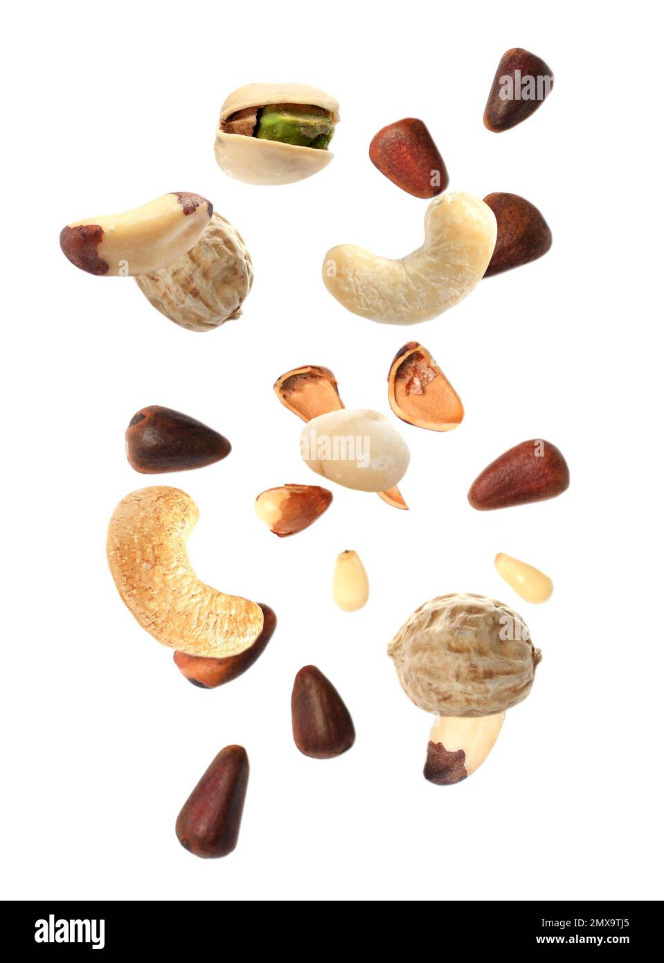 Different nuts falling on white background Stock Photo - Alamy