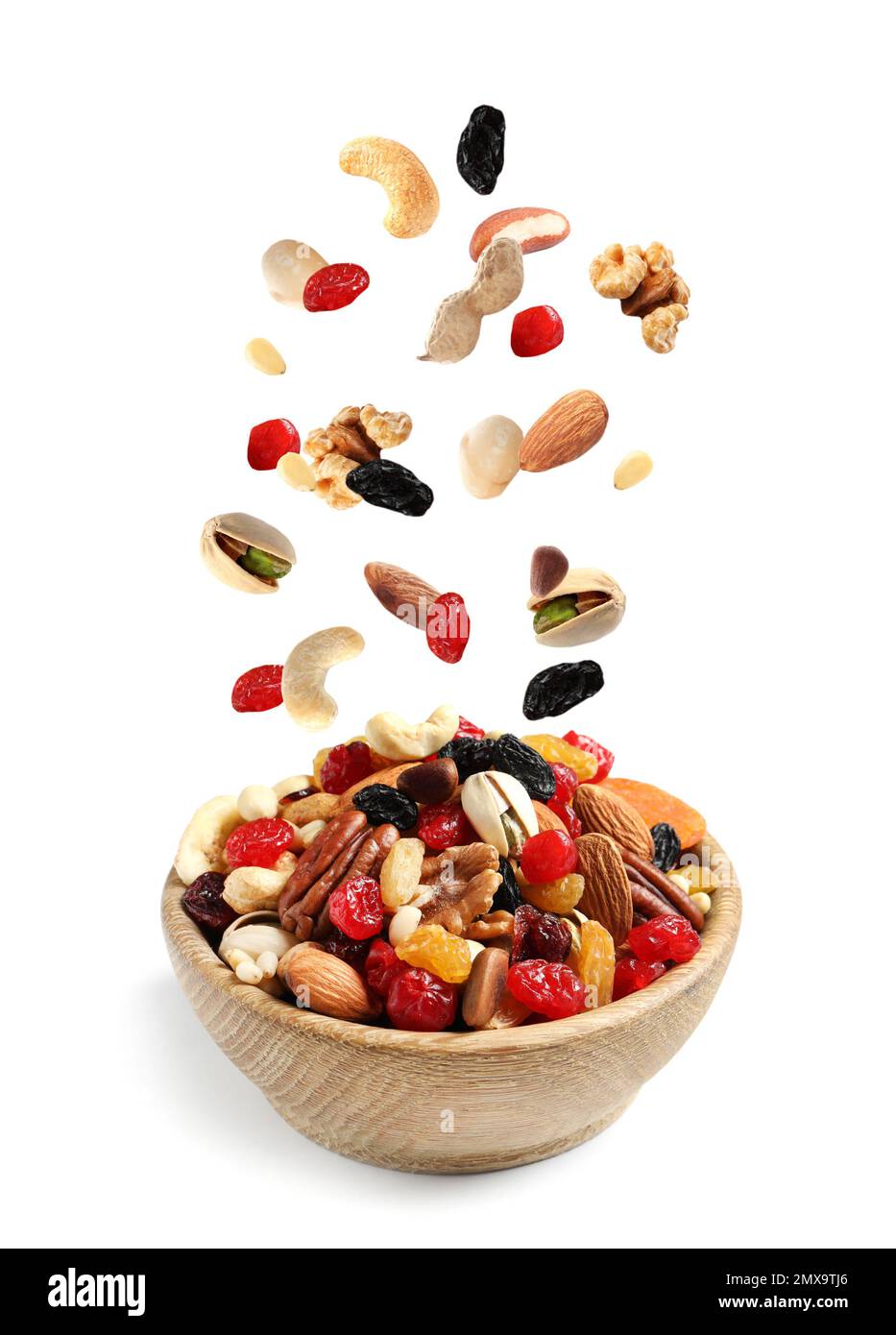 Different nuts falling into bowl on white background Stock Photo - Alamy