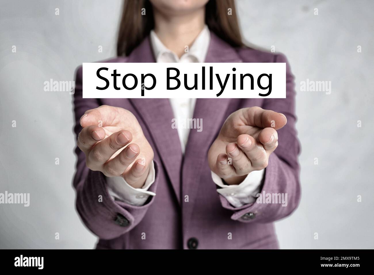 Young woman showing sign STOP BULLYING on light background, closeup ...