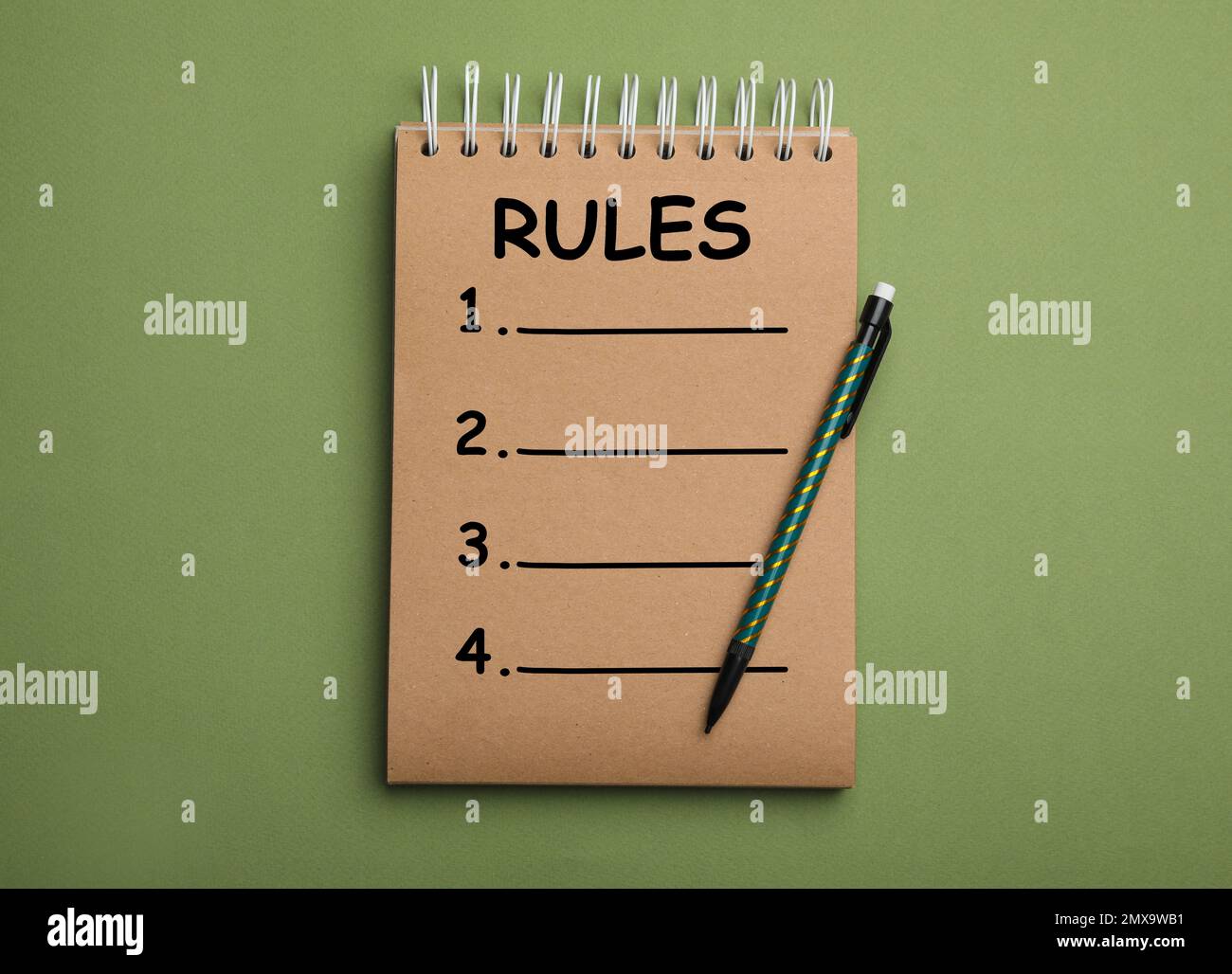 Kraft notebook with list of rules and pencil on green background, top ...