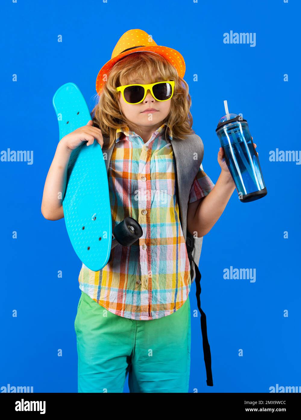 Childhood. Cute child with skateboard and water bottle on color ...