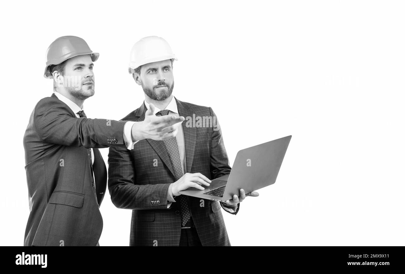 two engineers in suit and protective helmet use laptop isolated on ...