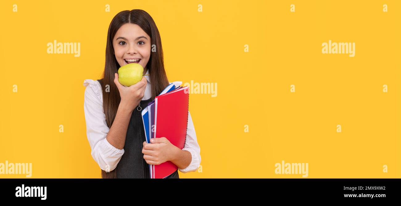 Being hungry for new knowledge. Happy schoolchild eat apple. Portrait ...