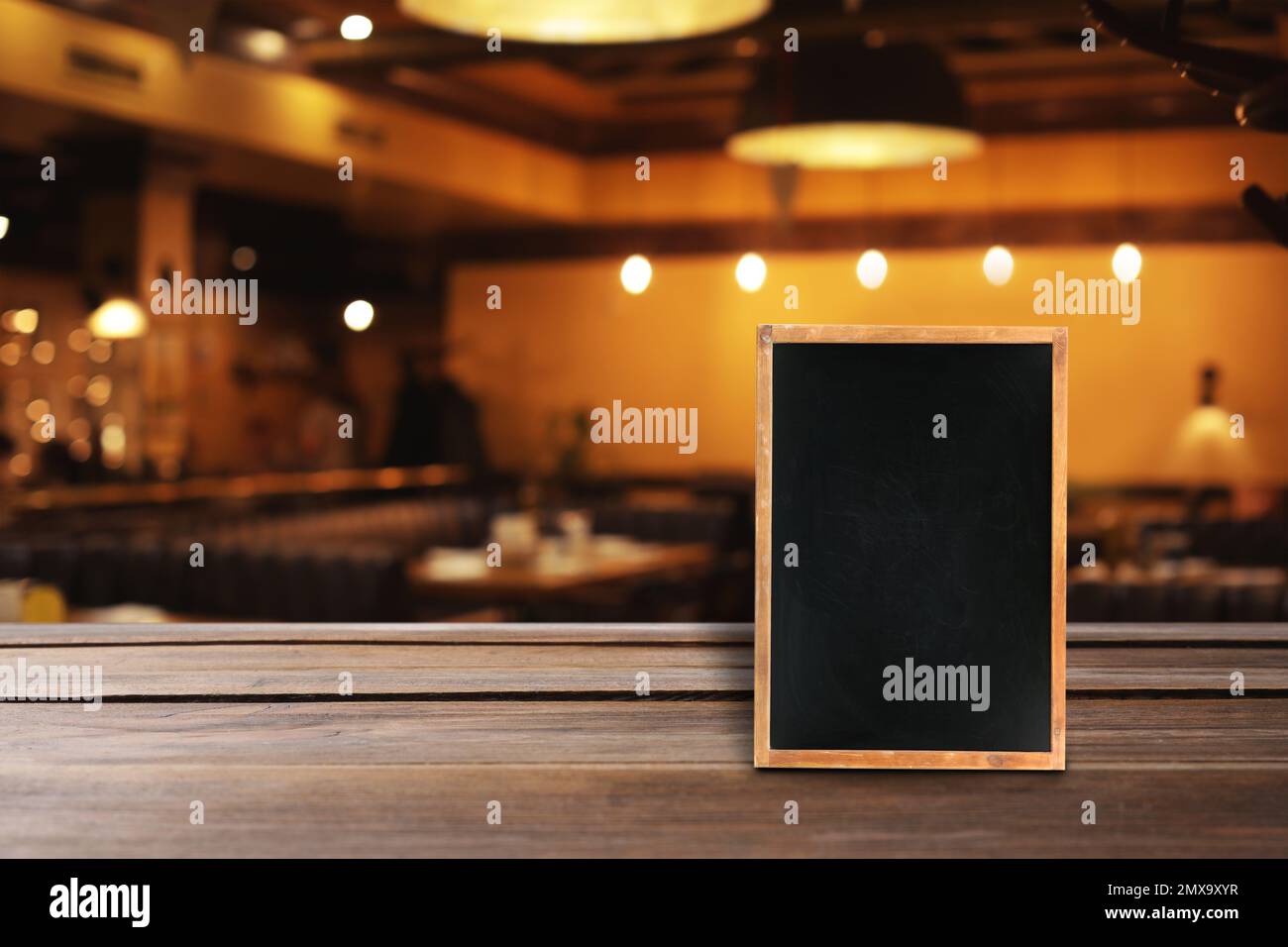 Blank small blackboard on wooden table in cafe, mockup for menu design ...