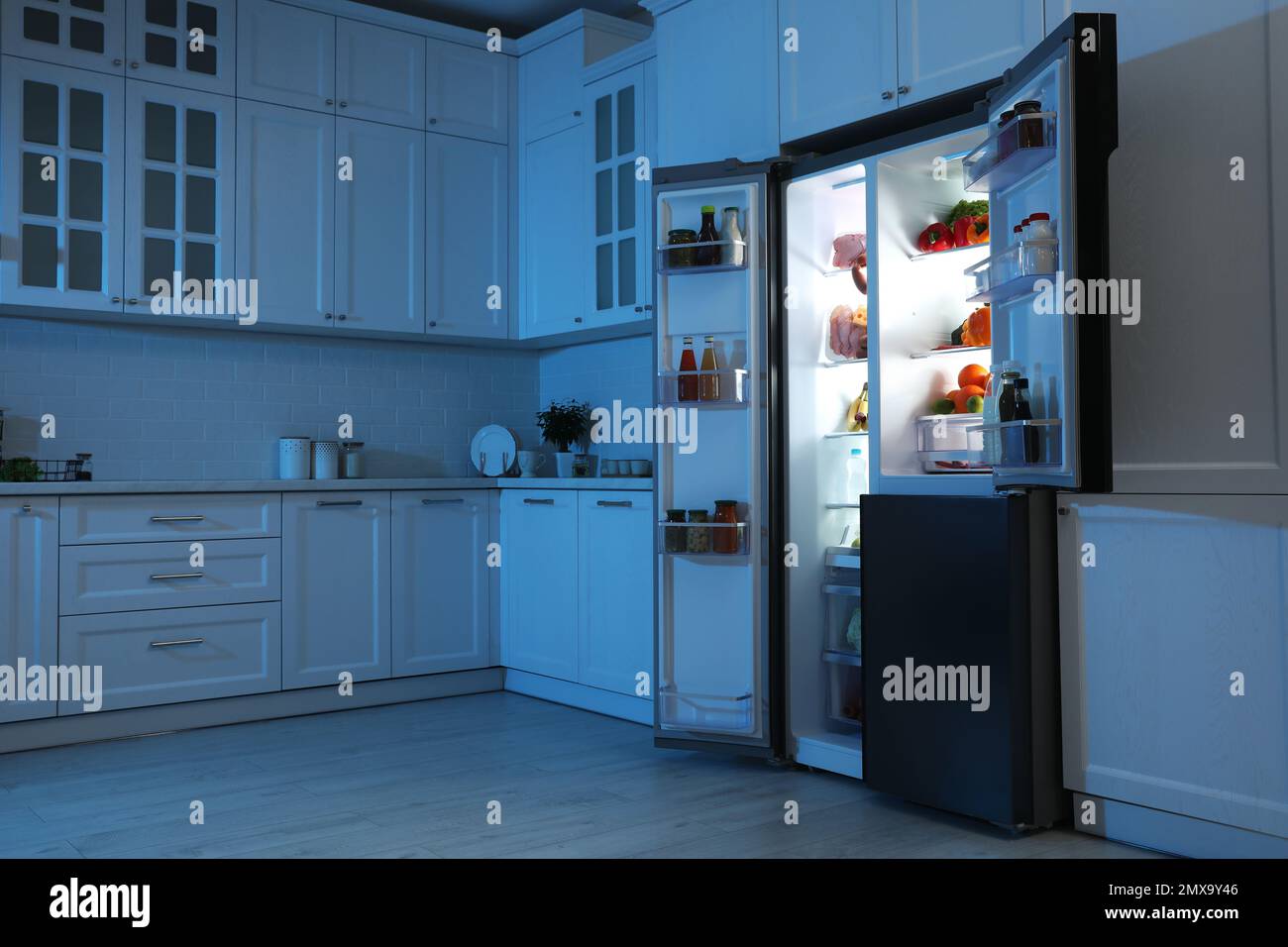 Open refrigerator filled with food in kitchen at night Stock Photo - Alamy