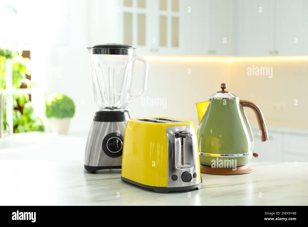 Set of modern home appliances on white marble table in kitchen Stock ...
