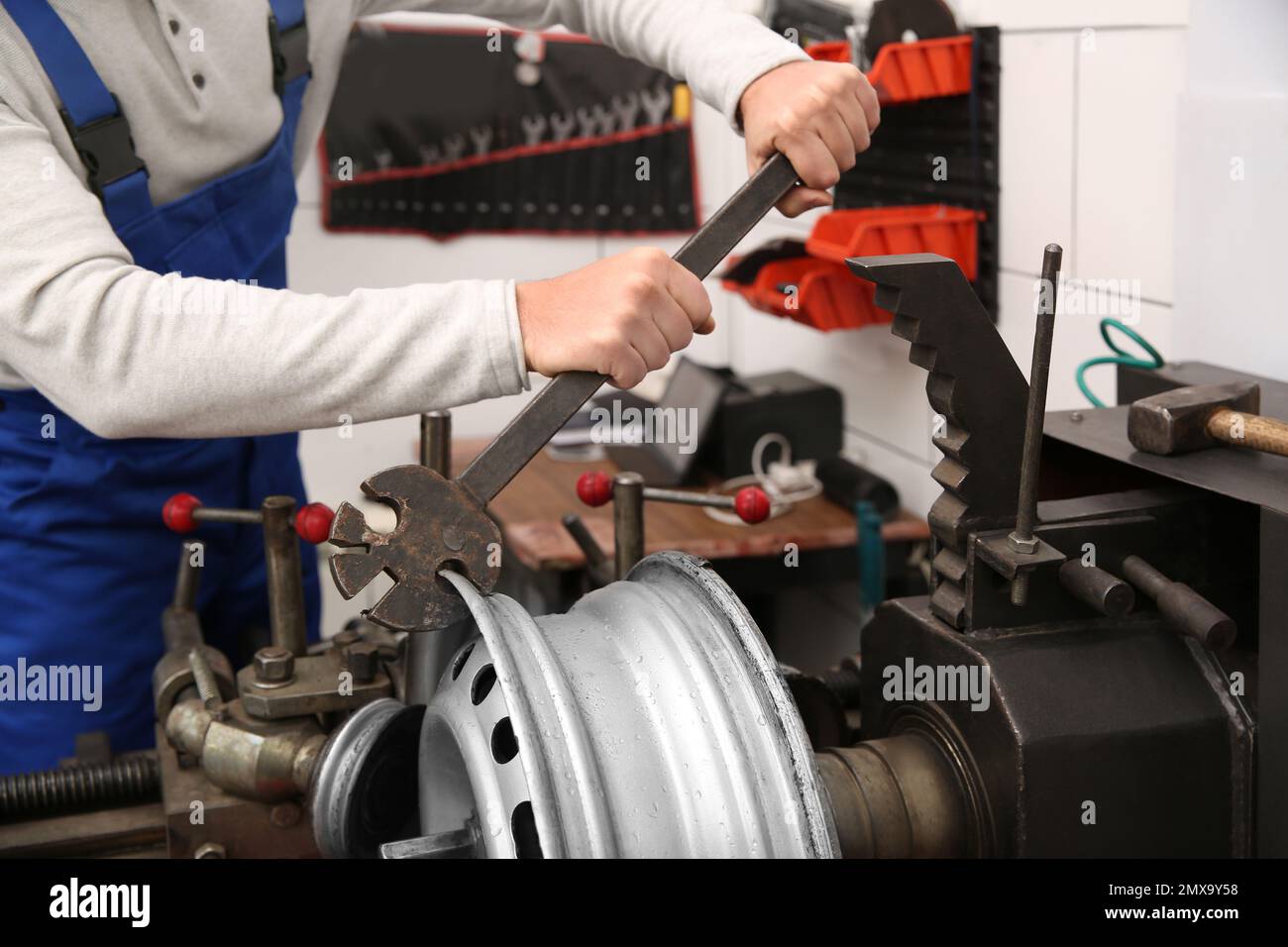 Mechanic working with car disk lathe machine at tire service, closeup ...