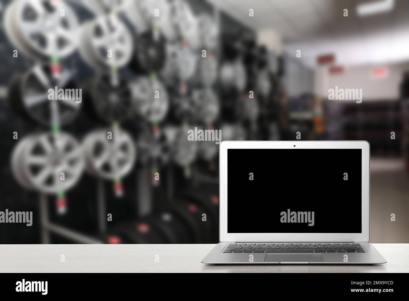 Modern laptop on table in auto store. Space for text Stock Photo - Alamy