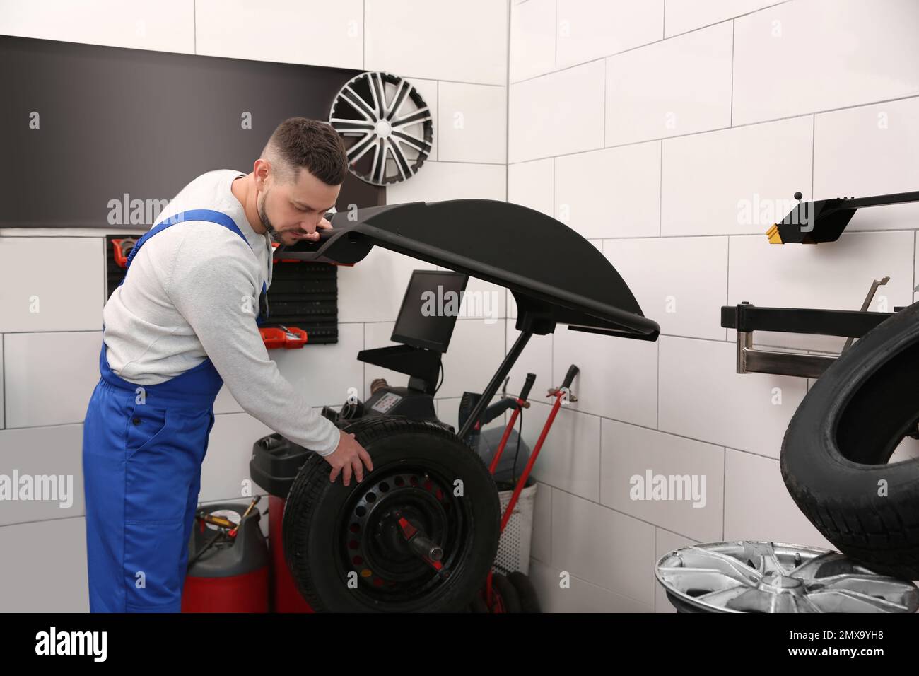 Mechanic working with wheel balancing machine at tire service Stock ...