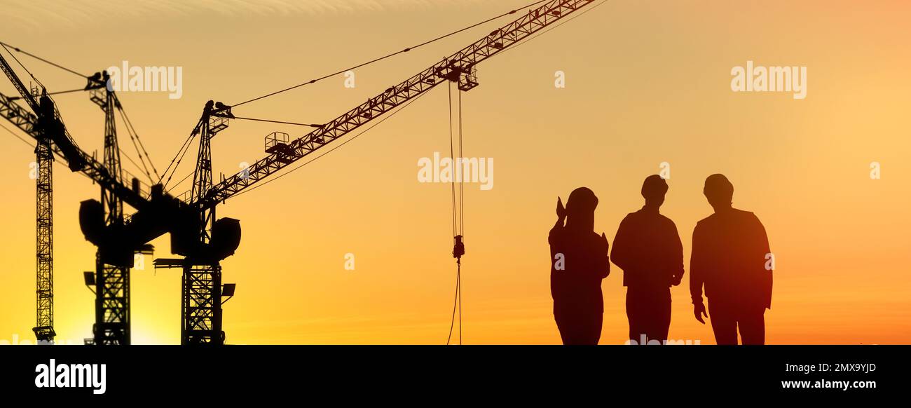 Silhouettes of engineers near construction site at sunrise. Banner ...
