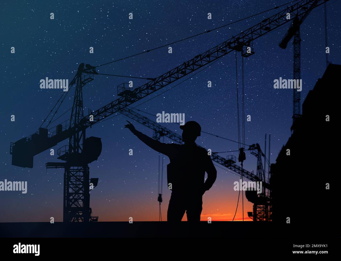 Silhouettes of engineer and construction crane at sunset Stock Photo ...