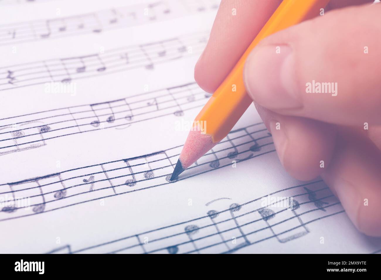 Woman writing music notes on sheet with pencil, closeup Stock Photo - Alamy