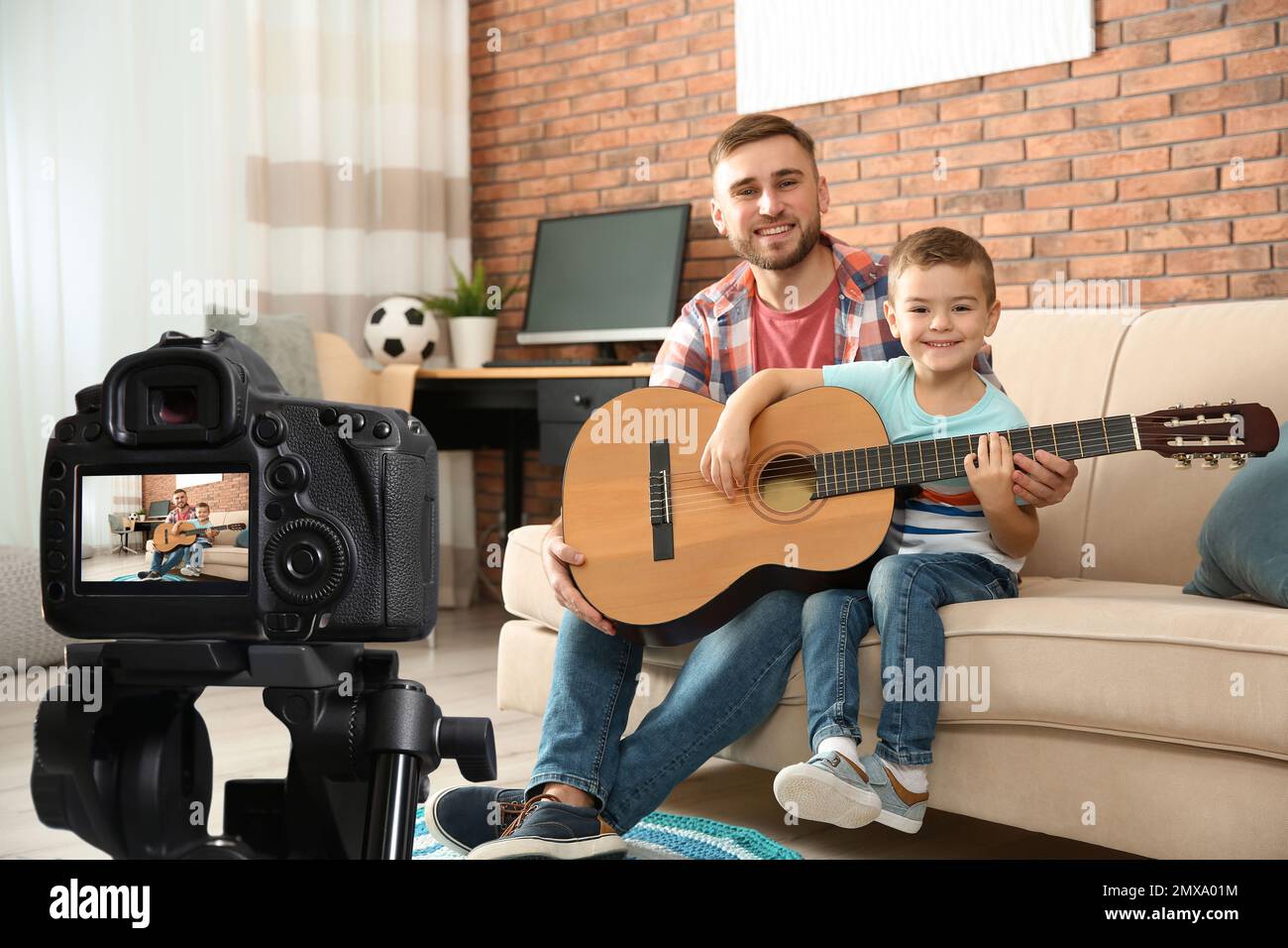 Father and son recording guitar lesson indoors. Teaching music Stock ...