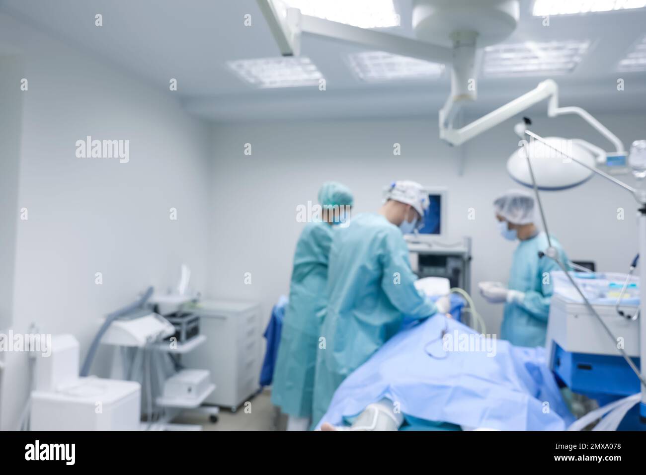 Blurred view of doctors operating patient in surgery room Stock Photo ...